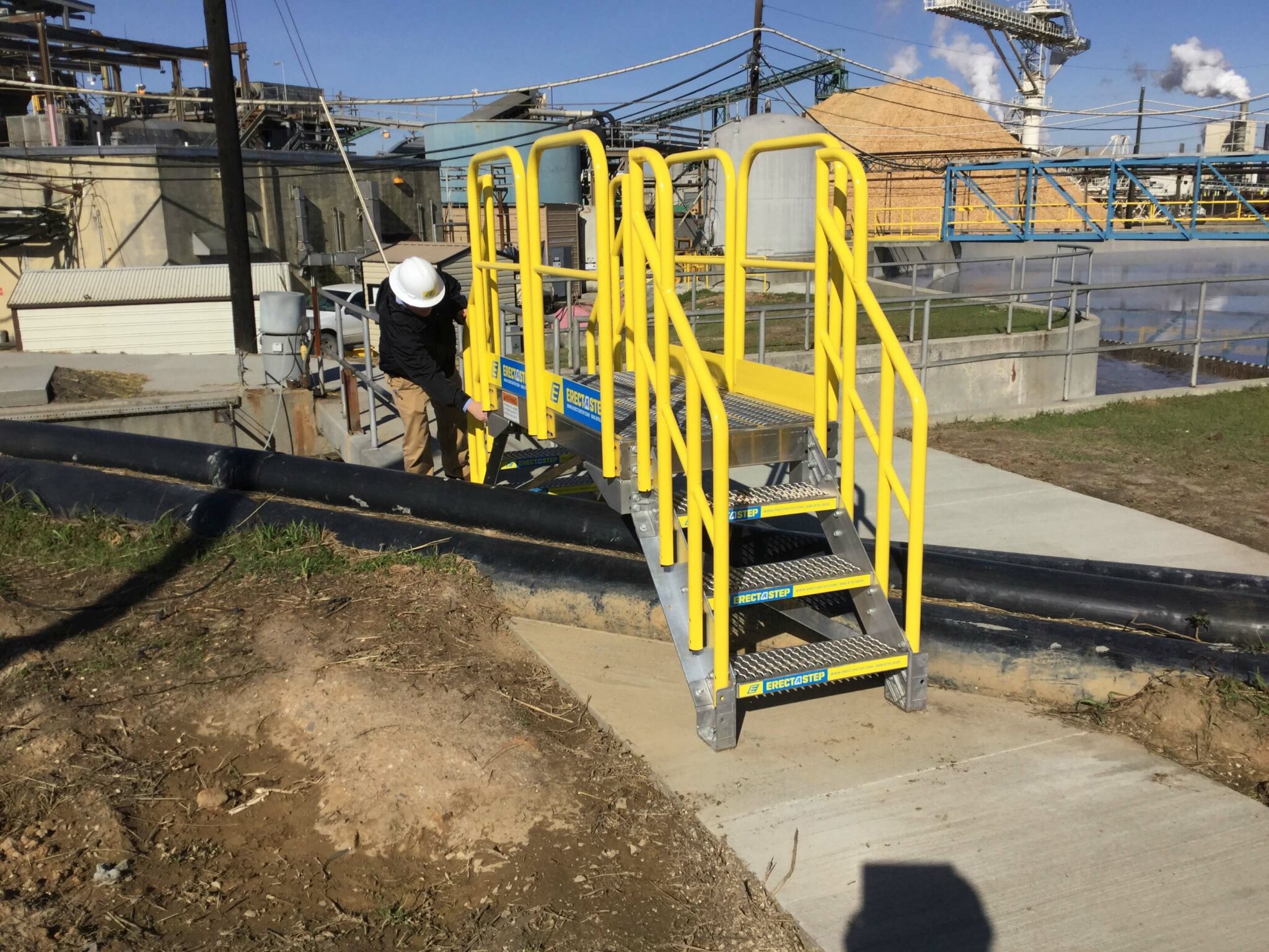 Erectastep industrial crossover stairs over outdoor pipe - ErectaStep