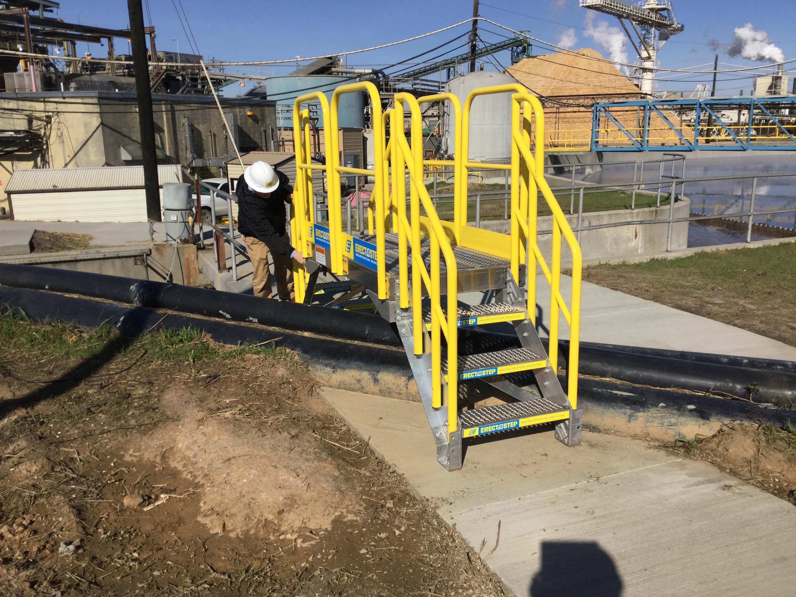 Erectastep industrial crossover stairs over outdoor pipe - ErectaStep