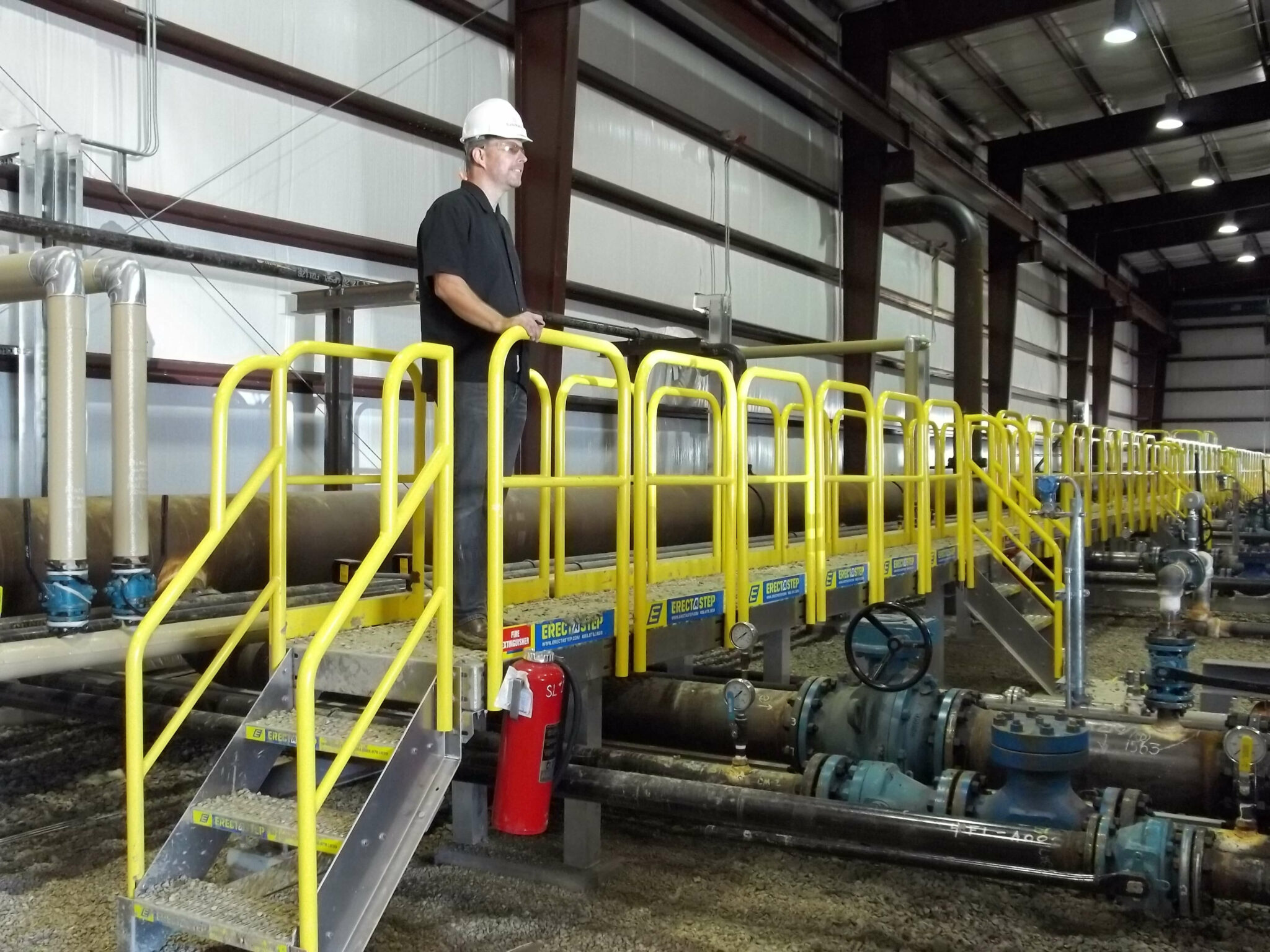 Erectastep pipe crossover stairs in manufacturing plant - ErectaStep